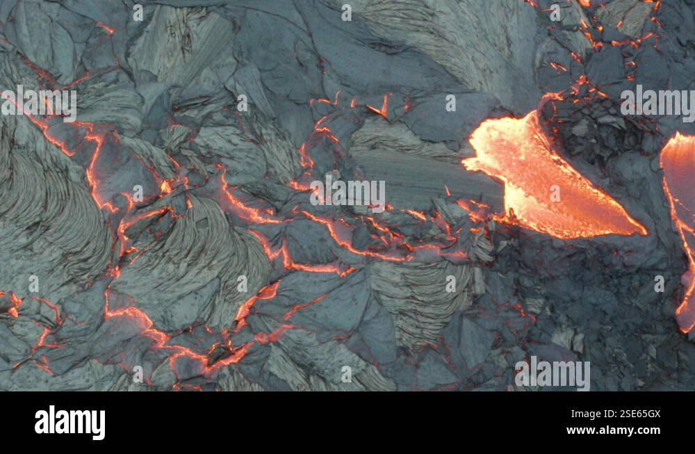 Burning flowing volcanic lava, birdseye aerial view, eruption of ...