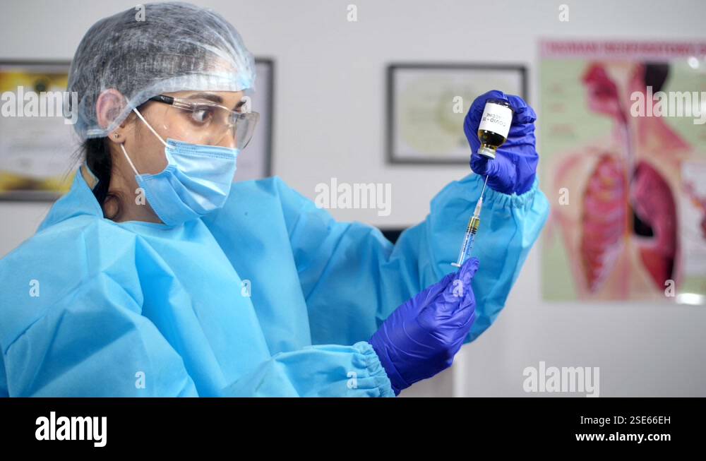 A female doctor wearing a personal protective suit (PPE Kit) preparing ...