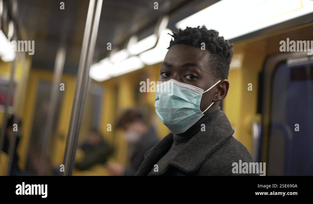 African man standing in subway metro wearing coronavirus mask ...