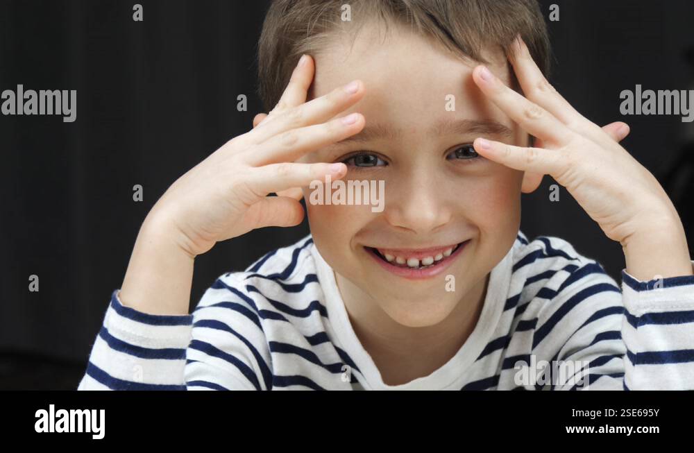 A kids face. Happy laughing baby. Cute little boy covers his face with ...