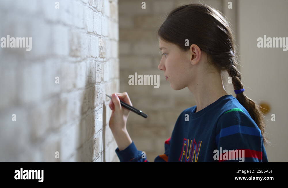 Girl writing math examples on wallpaper Stock Video Footage - Alamy