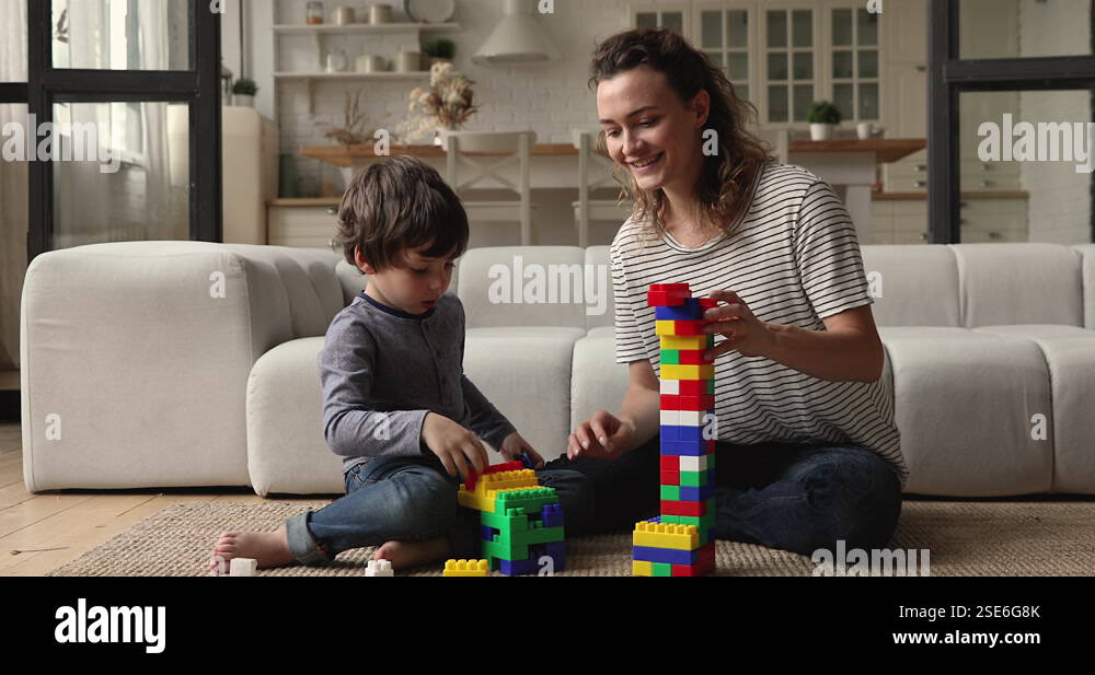 Mom teaches preschool son to build tower of colored block Stock Video ...