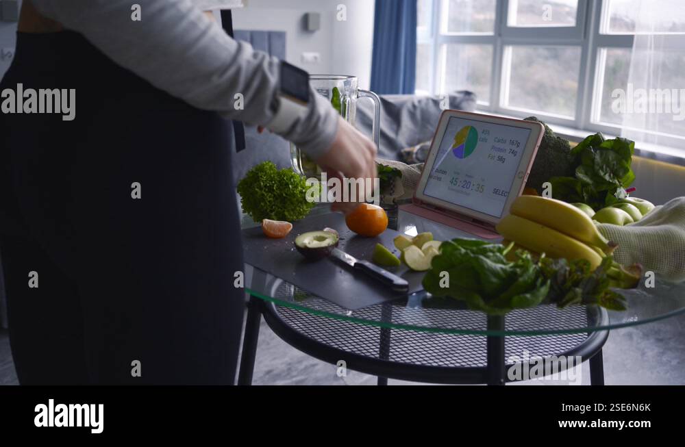 Woman puts fruits and vegetables into blender near tablet Stock Video ...