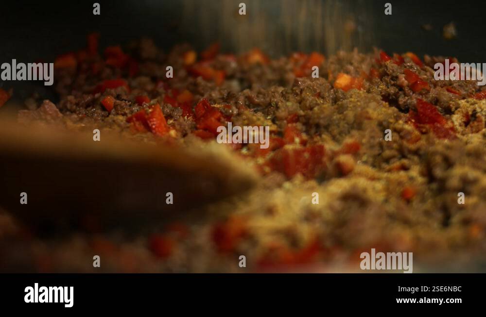Adding mexican spice mix to ground beef and red bell pepper cooking on ...