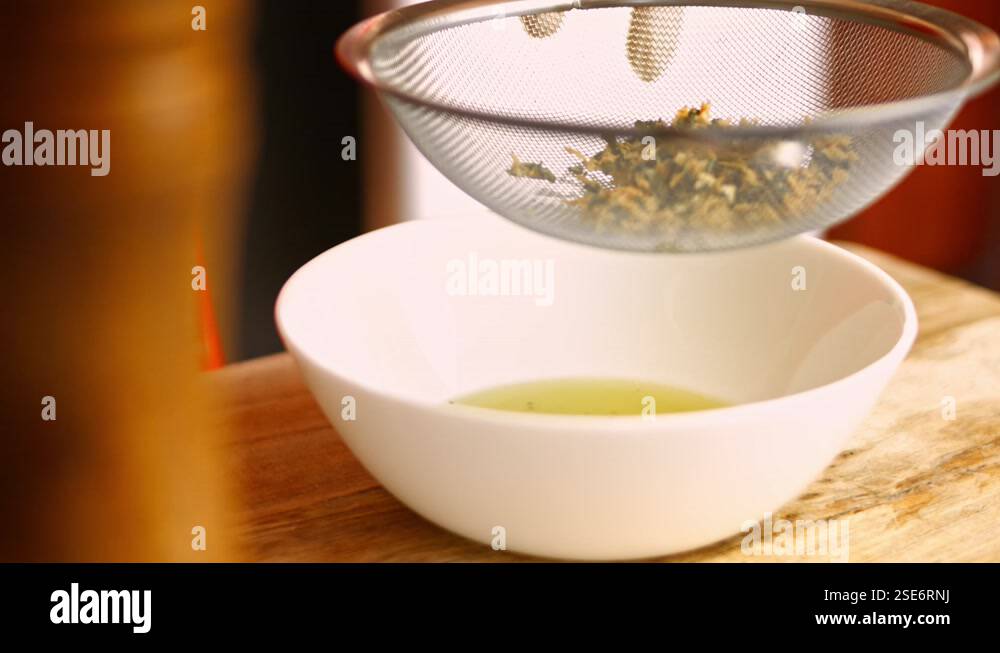 Straining through a sieve the fried garlic and chopped rosemary leaves ...