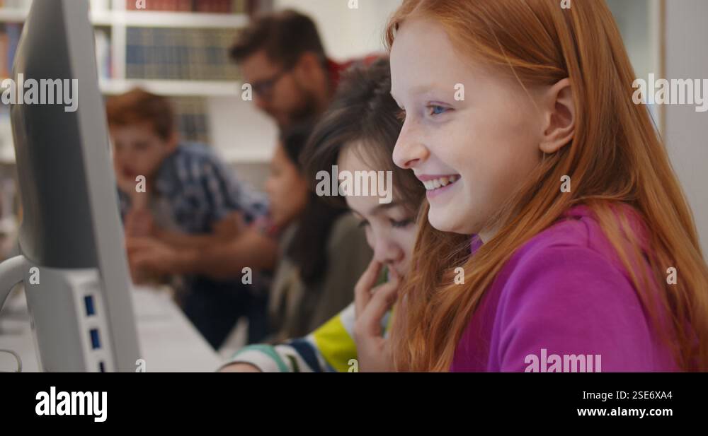 Multiethnic school kids using computer in classroom at secondary school ...