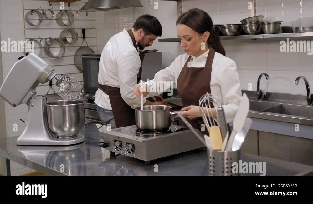 Two pastry chefs work in a pastry shop. Process of making a cake in the kitchen Stock Video ...