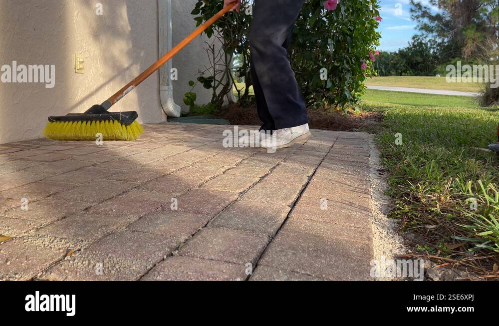 Man sweeping brick paver stone porch with push broom Stock Video ...