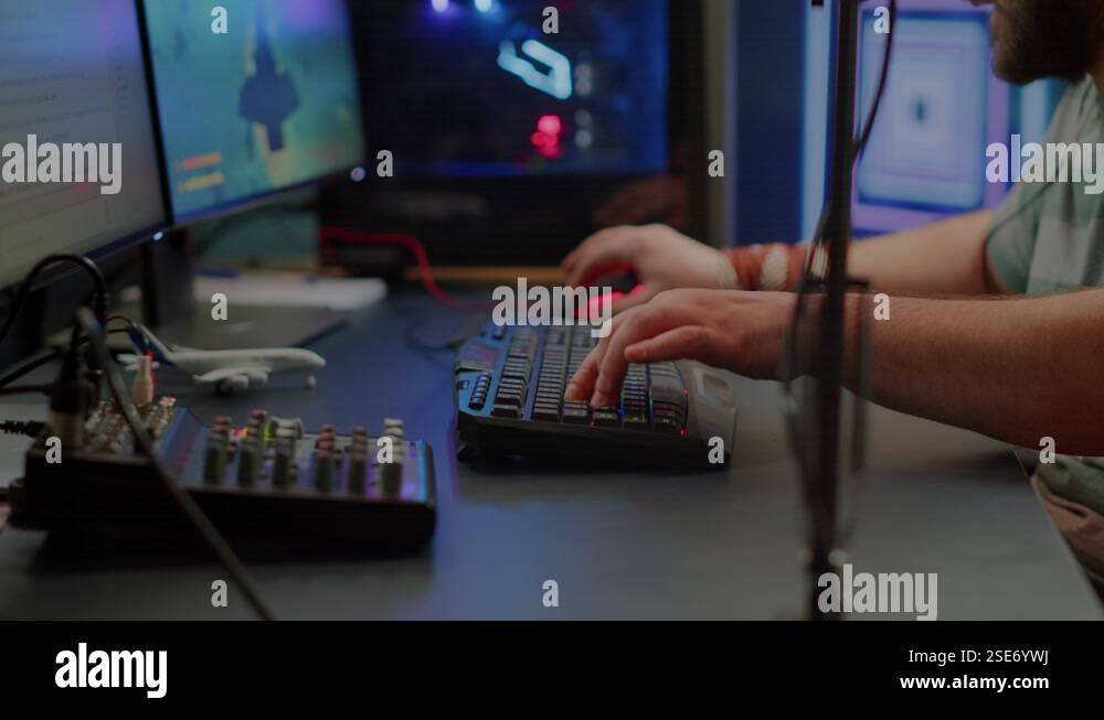 Close up of streamer typing at RGB keyboard playing space shooter ...