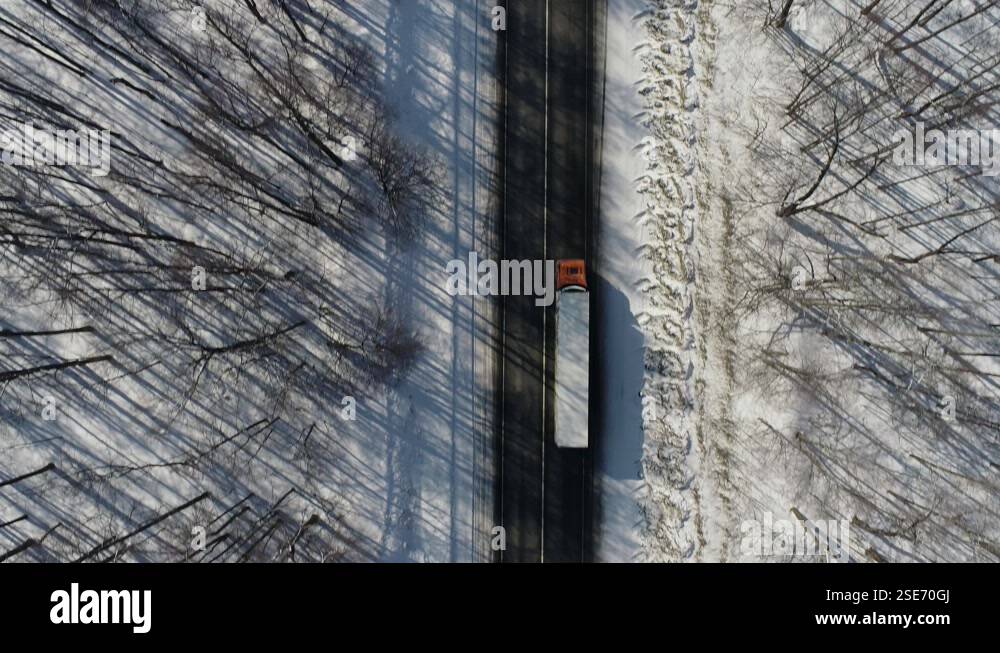 Semi truck with white trailer and cab driving alone on straight asphalt ...