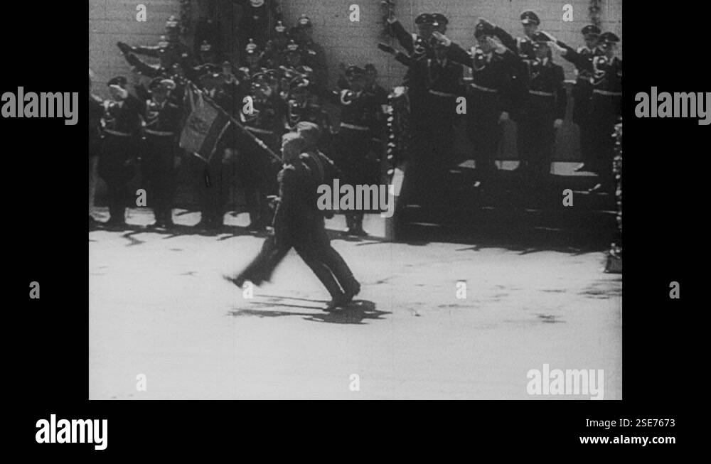 1930s Germany: Nazis march. Leaders stand. Nazi parade. Hitler gives ...