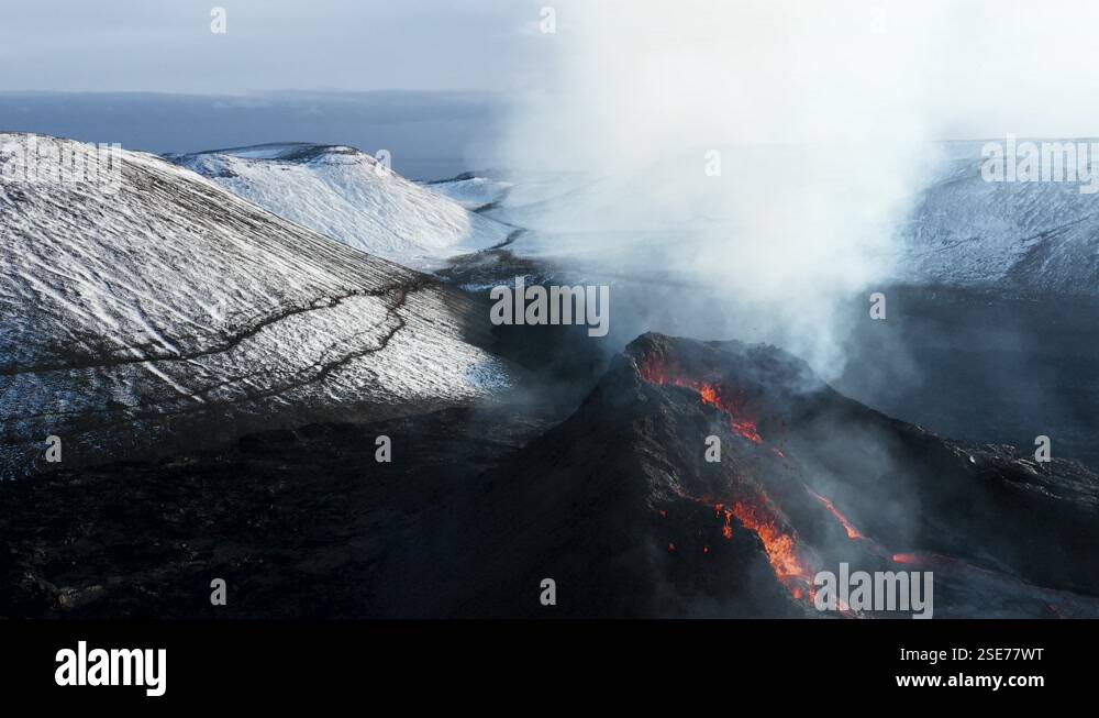 Spatter cone volcano ejecting hot molten magma from earths core, aerial ...