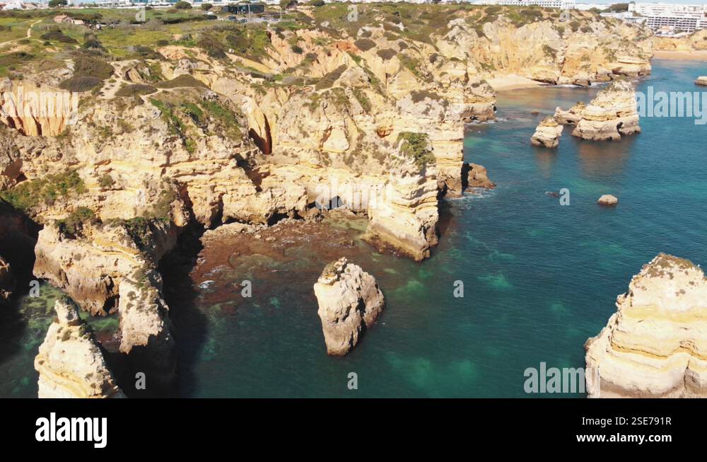 Little beachlets and caves carved into ochre cliffs by the Algarve sea ...