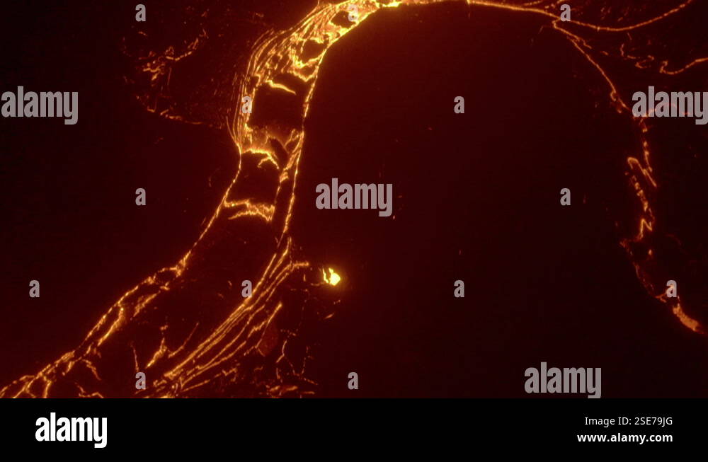 Flying over a fiery river of hot molten lava glowing red in the dark ...