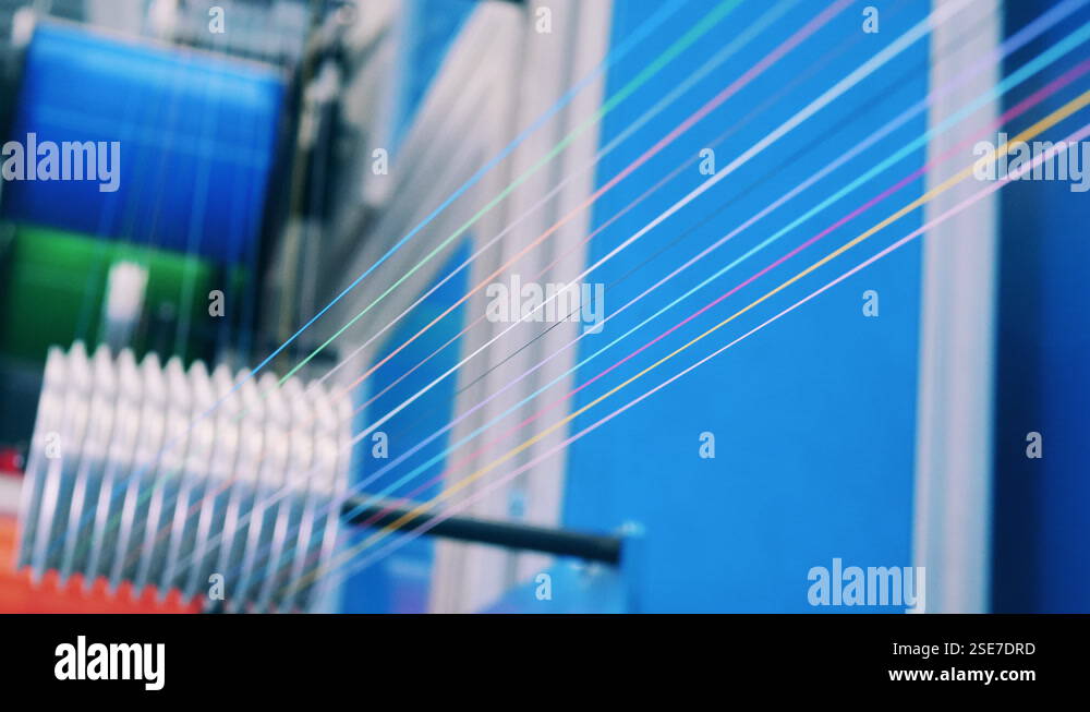 Multiple thin electric cables unwinding from a metallic spool. Modern ...