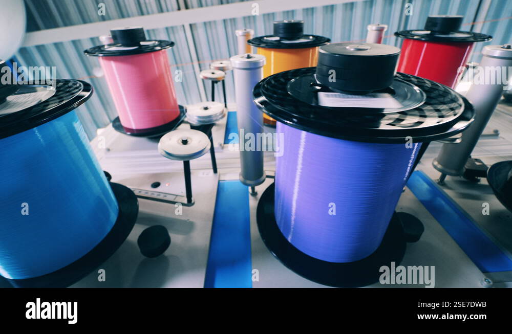 Modern industrial equipment. Bottom view of multiple spinning spools of ...