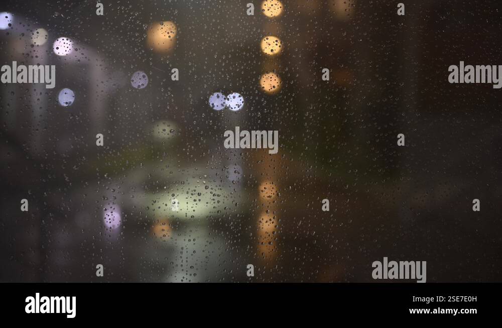 raindrops, splashes of rain dripping on the glass at night with the ...