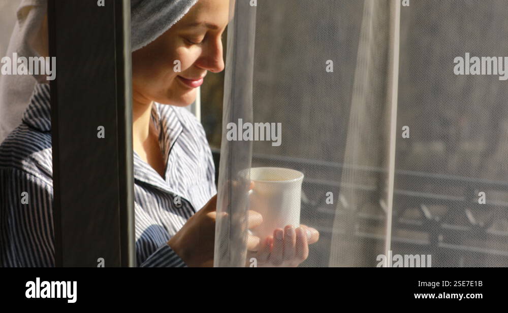 woman with a towel on her head is having breakfast on the balcony Stock ...