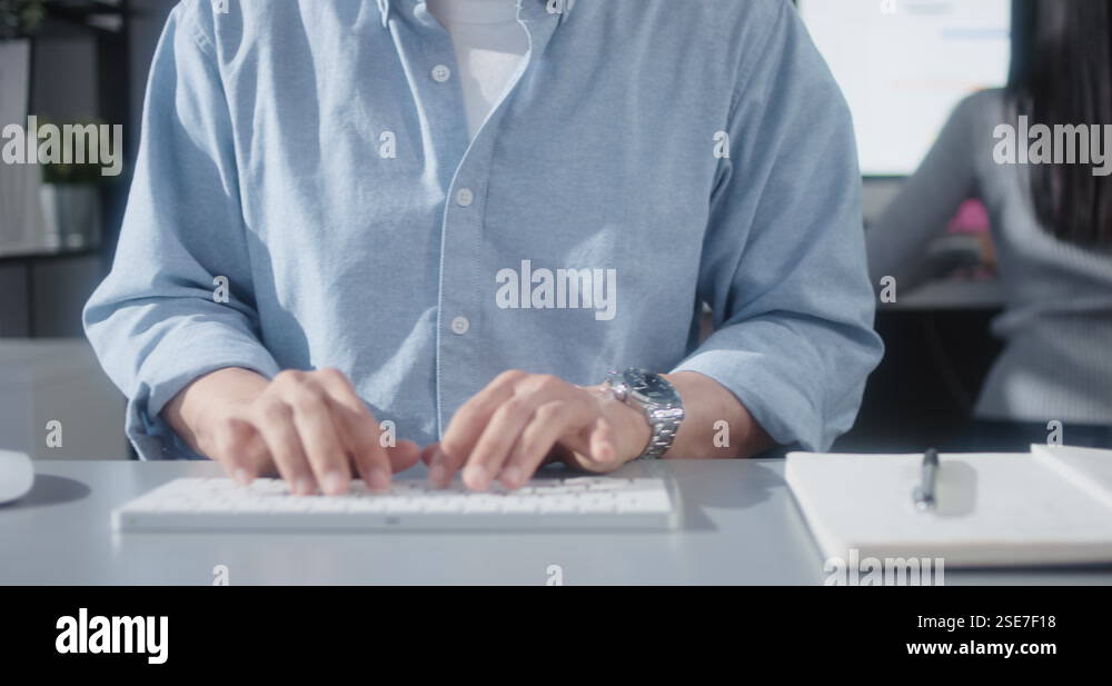 Asian man typing keyboard and click mouse on desktop computer in office ...