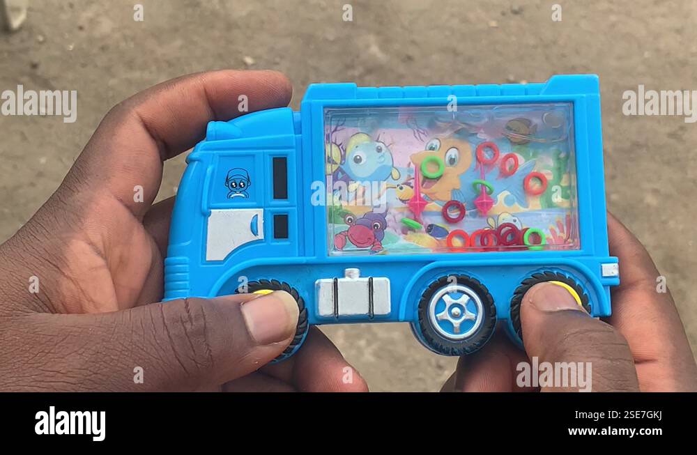 Close Up On Hand Playing An Handheld Water Game Ring Toss Toy Stock ...
