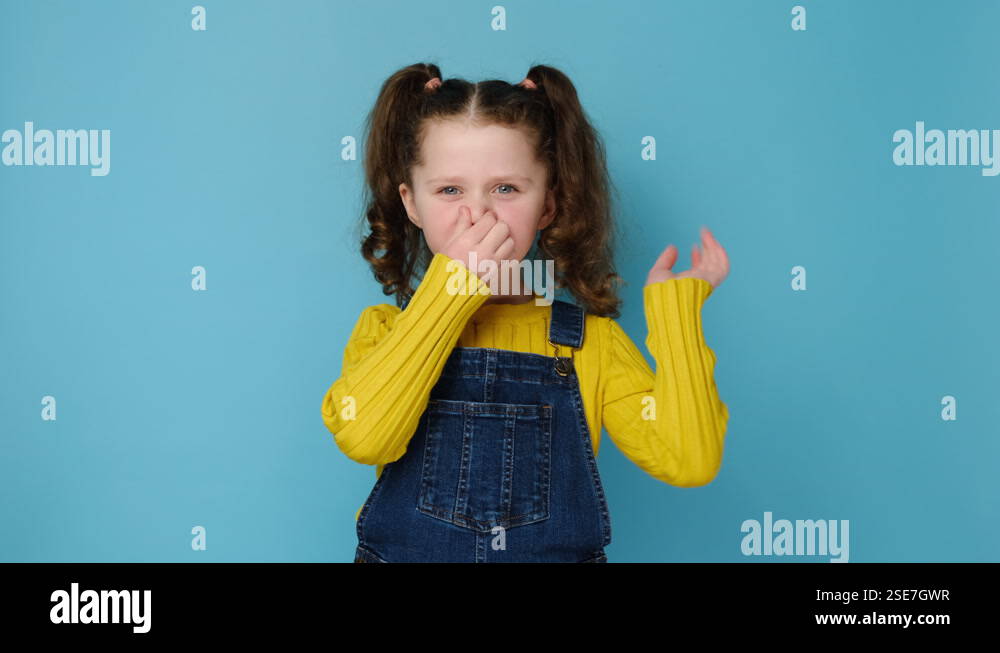 Little girl kid feeling bad and dislike smell and hold nose from funny ...