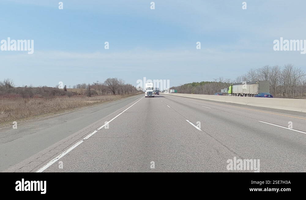 POV reverse shot driving on highway with truck and car traffic on nice ...