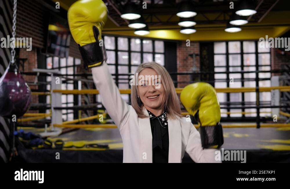 Business woman boxer in a suit and boxing gloves in the boxing ring ...