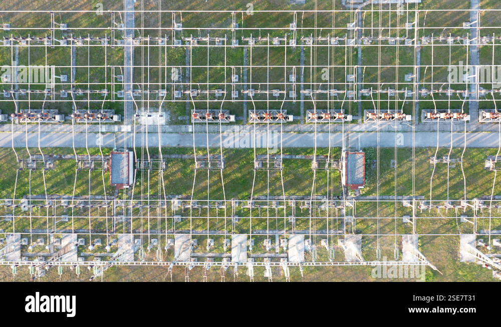 Electrical substation: transformers and grid of pylons, lines and wires ...