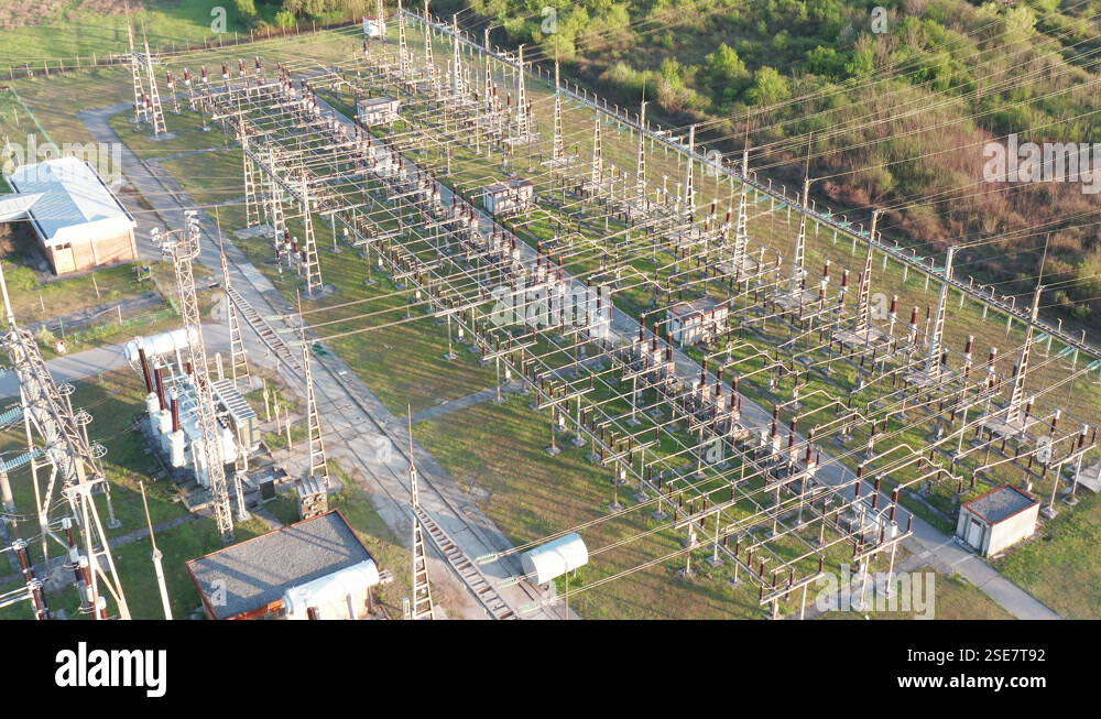 Electrical substation: transformers and grid of pylons, lines and wires ...
