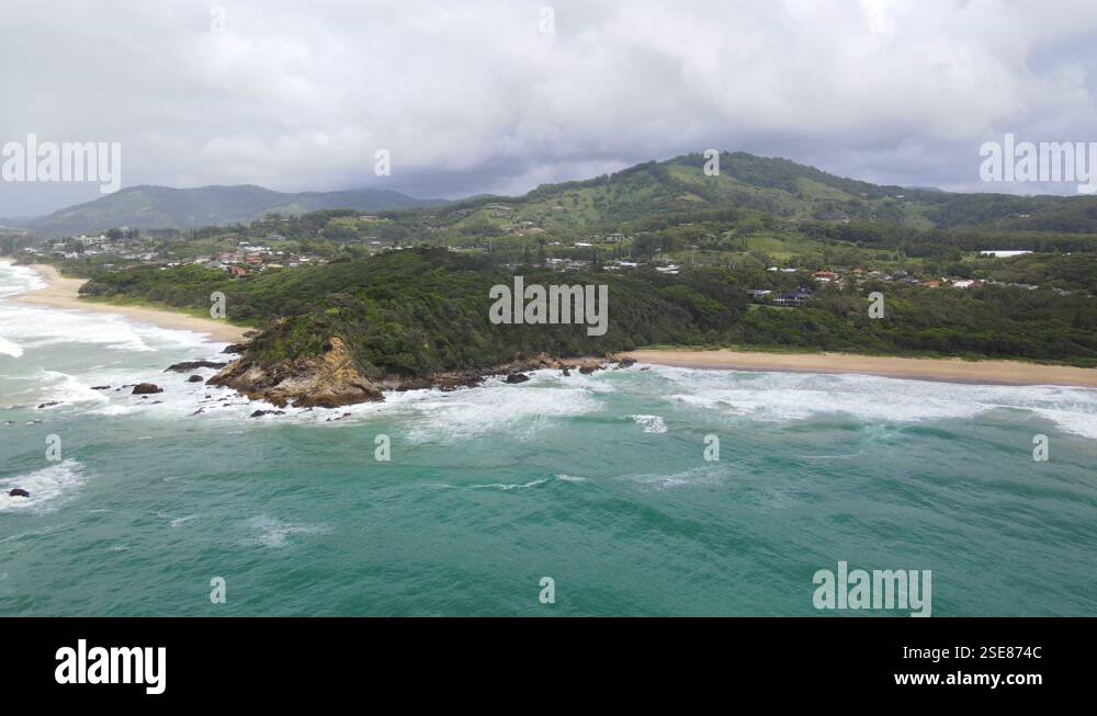 Cinematic Flight Above Wavy Ocean With Rough Cliff And Coastal Town In ...