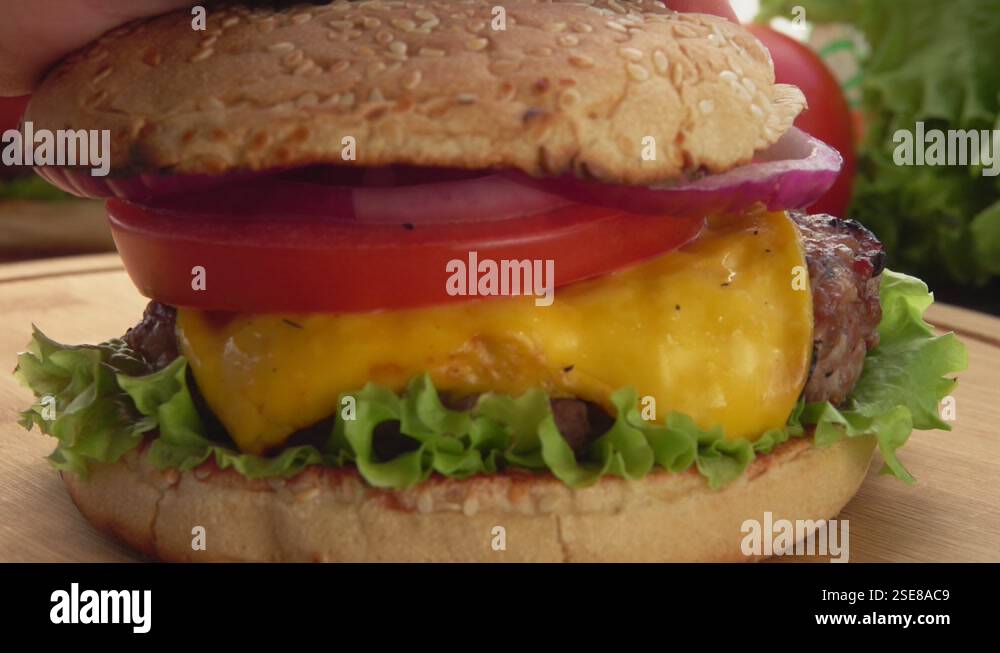 Super close-up of a fresh homemade grilled burger cut with a knife in ...