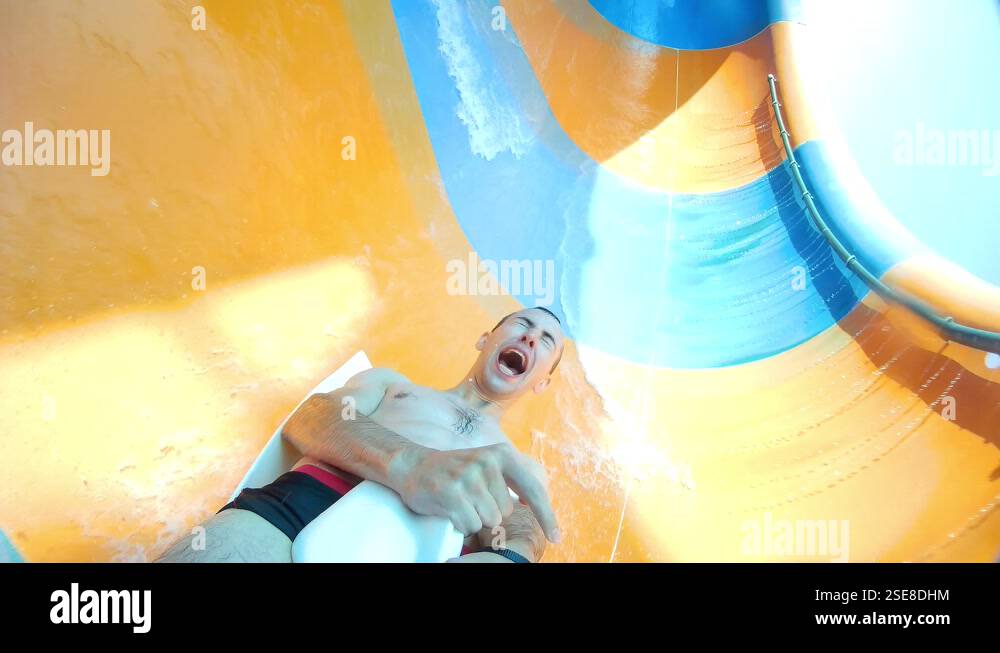 Funny ride on water slide pool in aqua park. Sliding down in waterpark ...