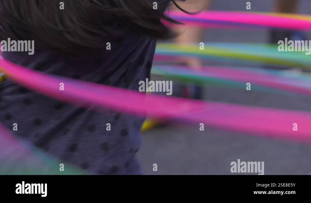 Young Child Using Colourful Hula Hoops Outside In Singapore Stock Video ...