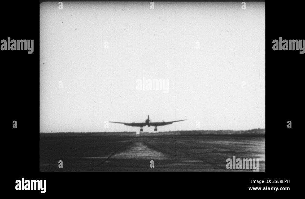 1940s: Plane flying overhead, landing on runway. Man signaling to plane ...