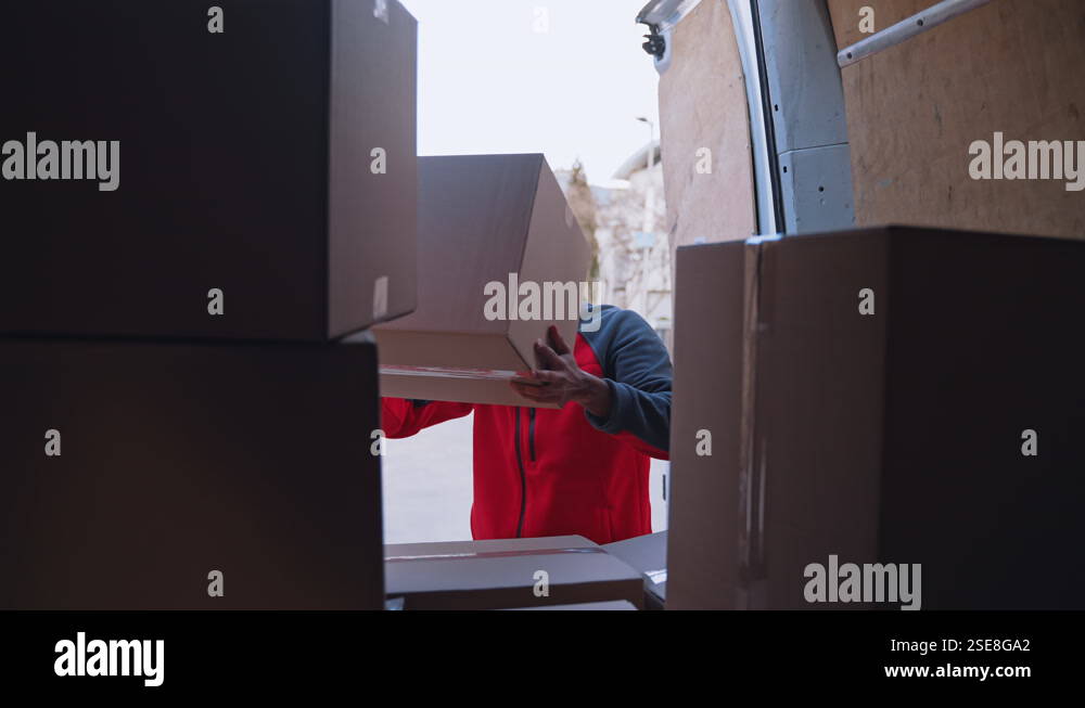 Young courier unloading parcels from the truck Stock Video Footage - Alamy