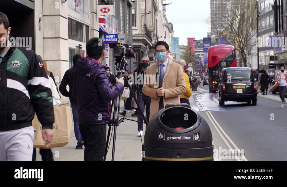 Foreign Asian news reporter wearing mask in Oxford street London Stock ...