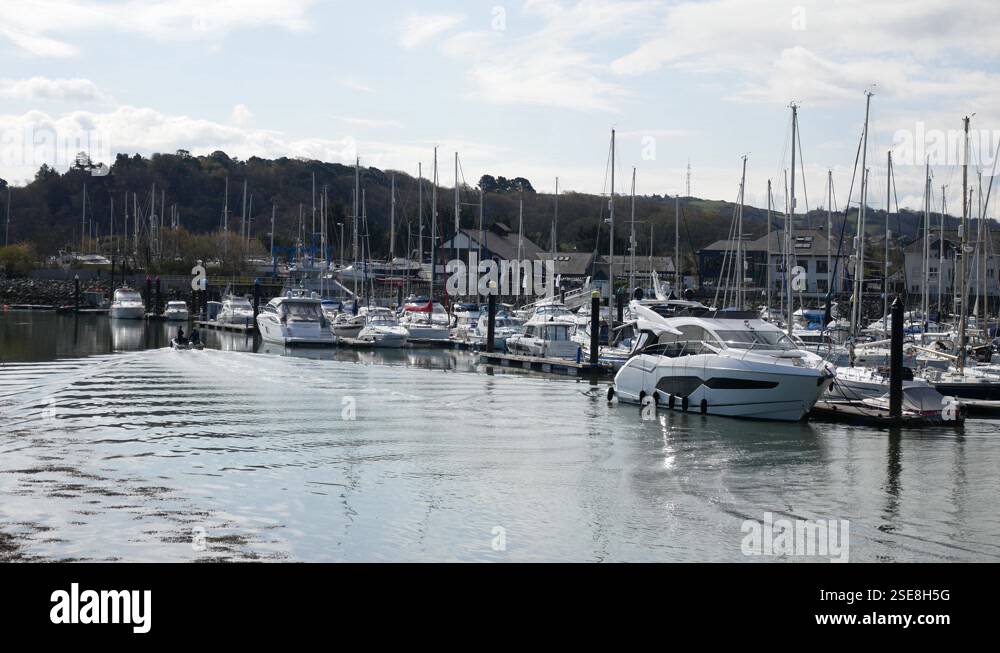 Fishing boat leaving sunny luxury Conwy marina North wales waterfront ...