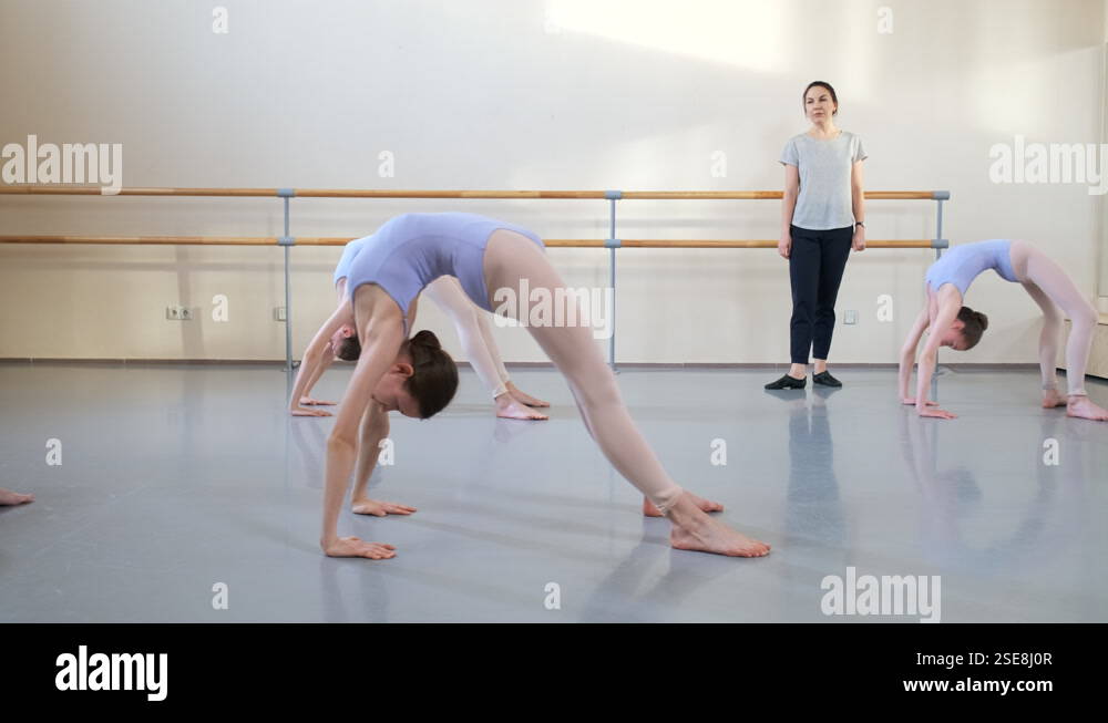 Girls at ballet gymnastics class doing bridge pose exercise, dance ...