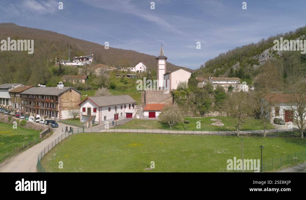 Majestic small church tower in hillside town in low angle drone view ...