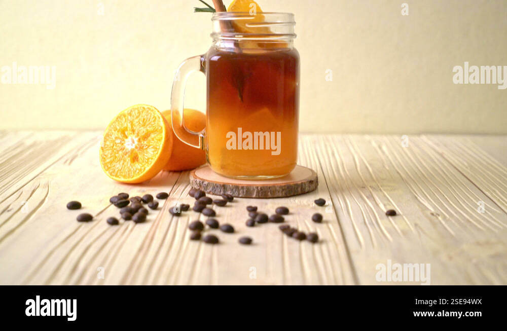 A glass of iced americano black coffee and layer of orange and lemon ...
