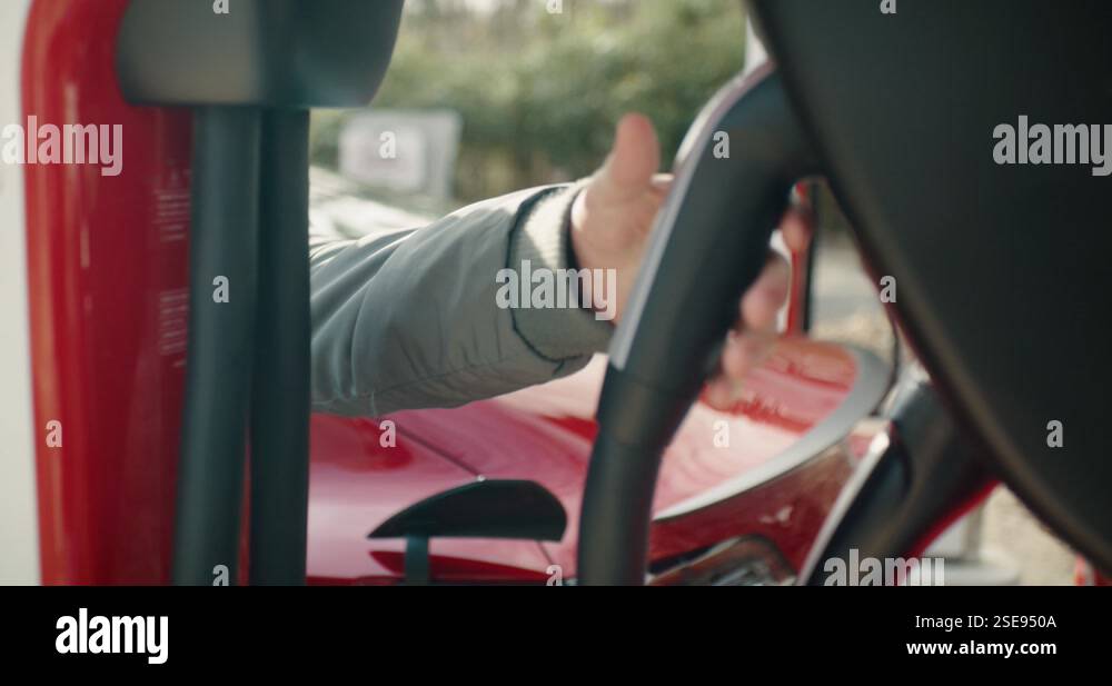 The charge port flap of the car is opened and the charging cable is ...