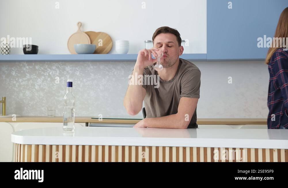 A drunken man with alcoholism feels depressed while sitting at home ...
