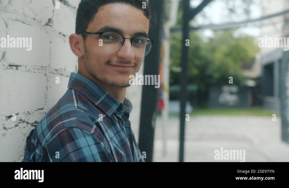 Joyful Arab guy turning to camera and looking with cheerful face ...