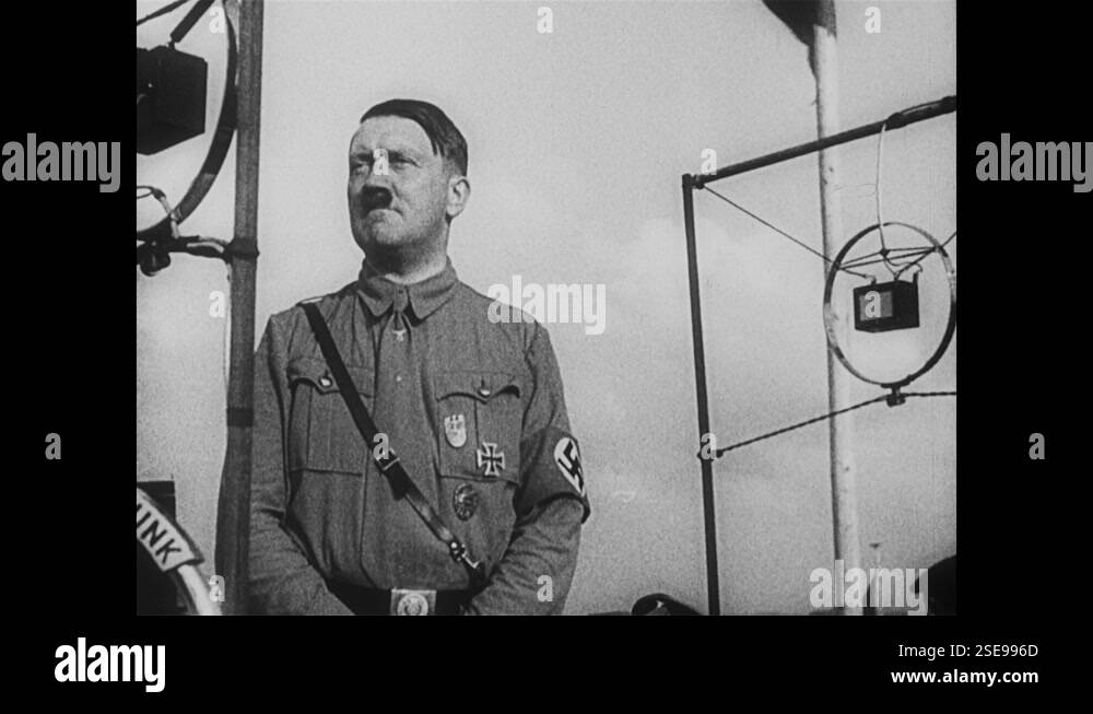 1930s Germany: Crowded stadium. Hitler yells and gestures. Soldiers ...