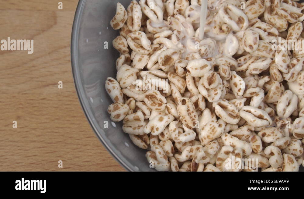 Pouring milk into a bowl with dry puffed spelt wheat Stock Video ...