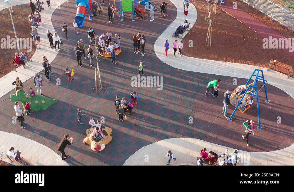 Playground for kids in a park, busy with children having fun and ...
