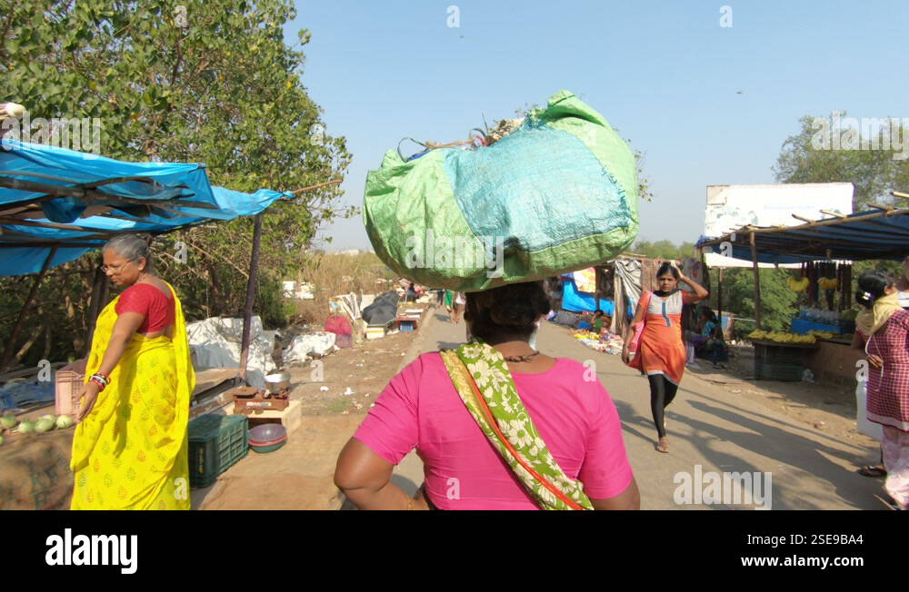 Indian villager woman walking on road with heavy bag overhead, Mumbai ...