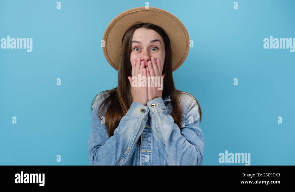 Surprised young female turn around camera covering mouth spreading ...