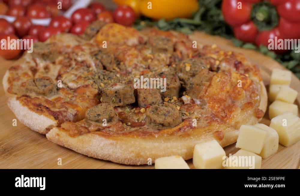 Chicken sausage pizza is being seasoned with spicy hot chilly flakes ...