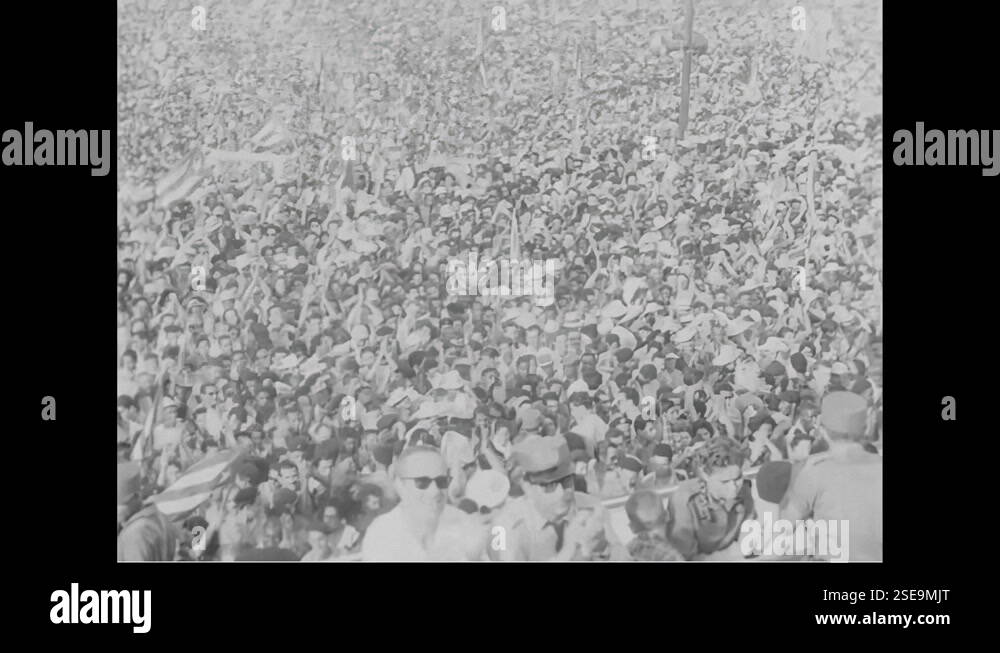 1960s Enthusiastic crowd gathers at a vibrant rally in Cuba, captivated ...